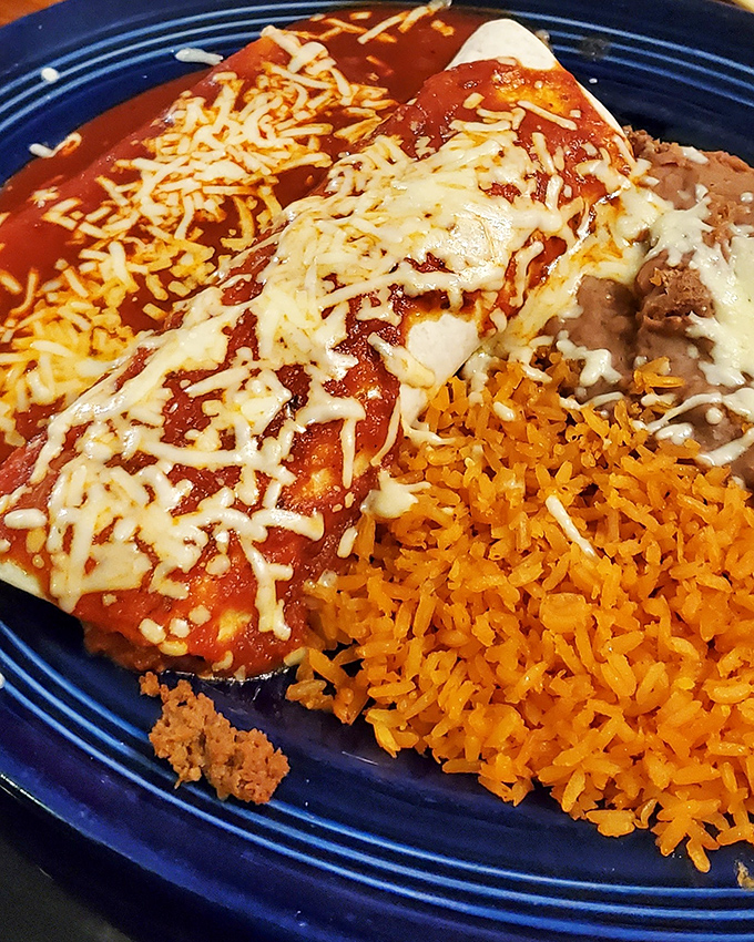 Enchiladas bathed in that brick-red sauce that haunts your dreams. The rice and beans aren't sidekicks—they're essential supporting actors in this cheesy blockbuster.