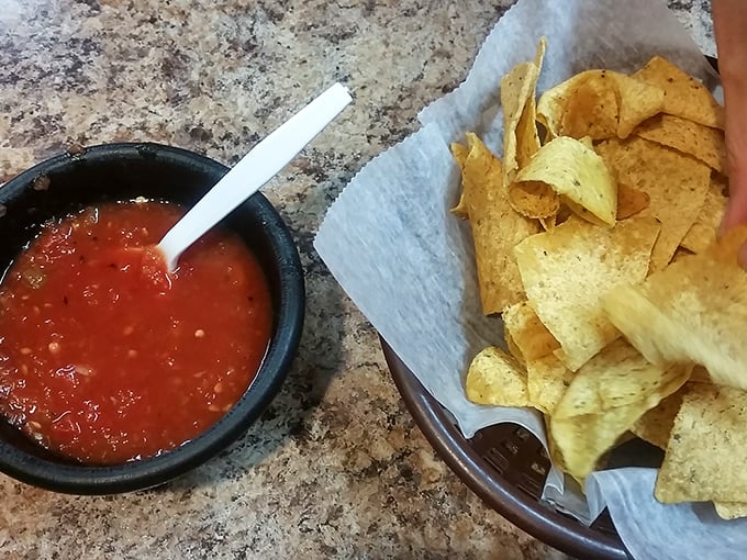 The holy trinity of Mexican starters—vibrant salsa, crisp chips, and hot sauces that range from "pleasant warmth" to "I can see through time."