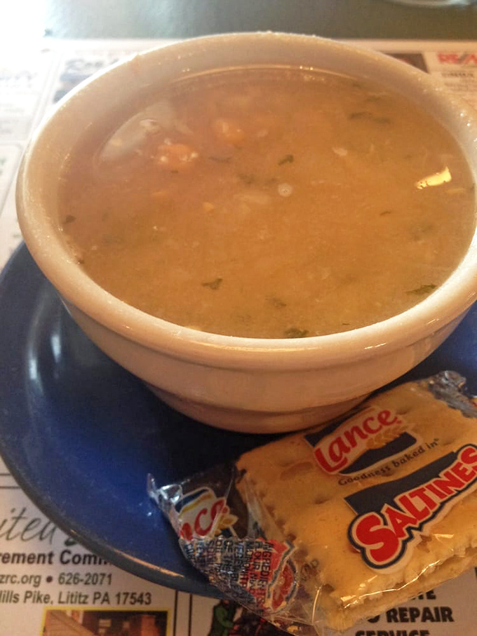 The legendary chicken corn soup – golden broth, tender chicken, sweet corn kernels, and delicate egg ribbons – served with crackers for proper dunking.