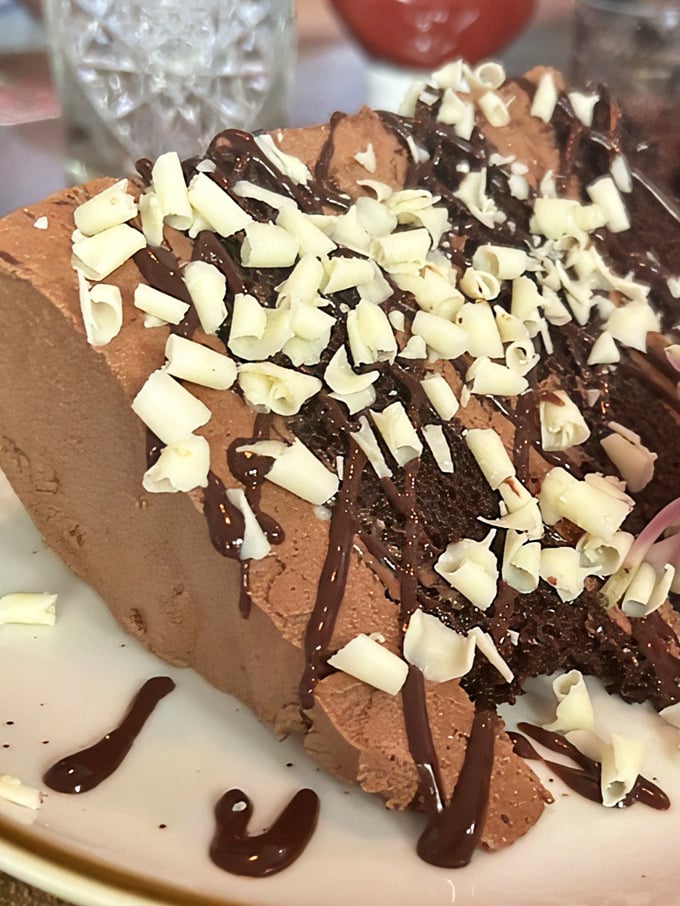 The chocolate mousse cake that launched a thousand return visits. Those white chocolate shavings aren't just decoration—they're exclamation points.
