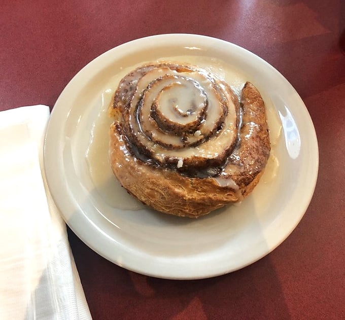 This cinnamon roll isn't just breakfast—it's an architectural marvel of spiraled dough and glaze that demands to be admired before being devoured with childlike enthusiasm.