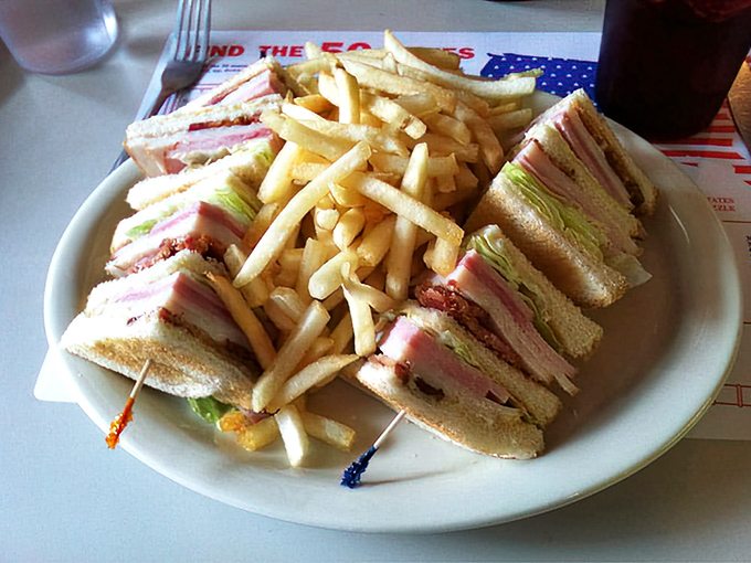 The club sandwich—architecture you can eat. Three stories of deliciousness held together with toothpick engineering.