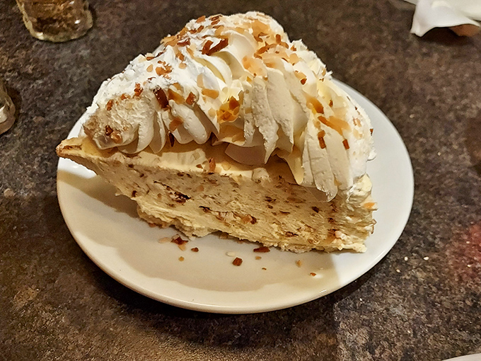 Coconut cream pie topped with toasted flakes and whipped cream—a dessert so good you'll contemplate ordering a second slice before finishing the first.