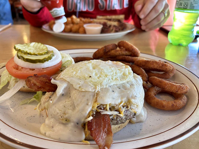 This breakfast sandwich, smothered in country gravy with onion rings on the side, isn't just comfort food—it's a warm hug on a plate.