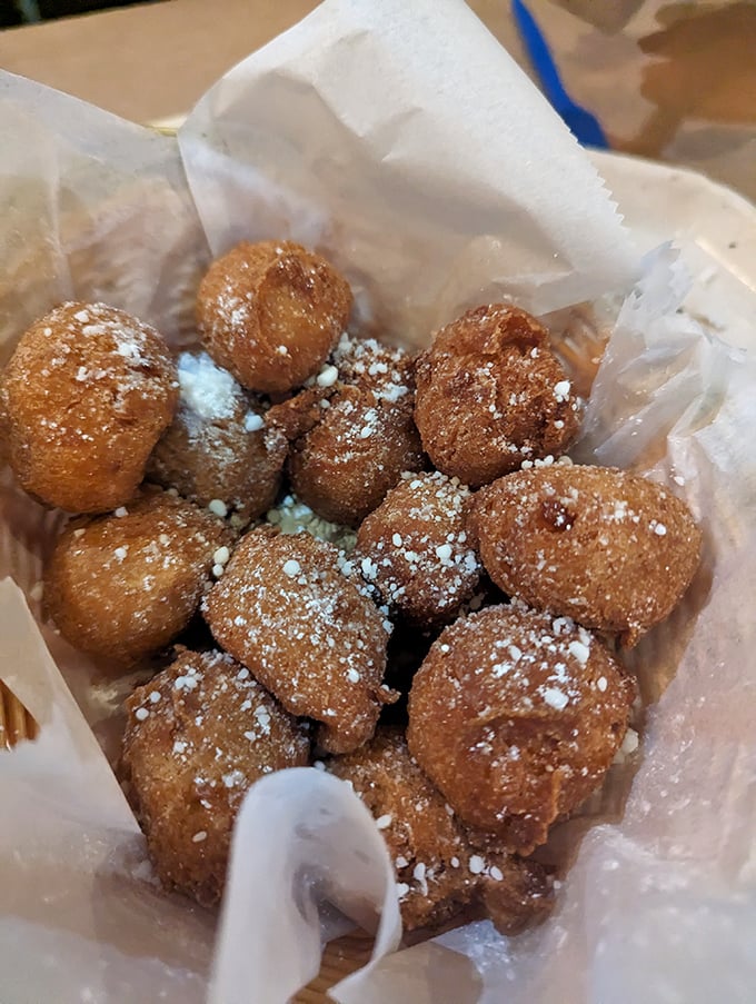 Corn fritters that look like they're wearing little powdered sugar snowcaps—crunchy outside, fluffy inside, and utterly irresistible.