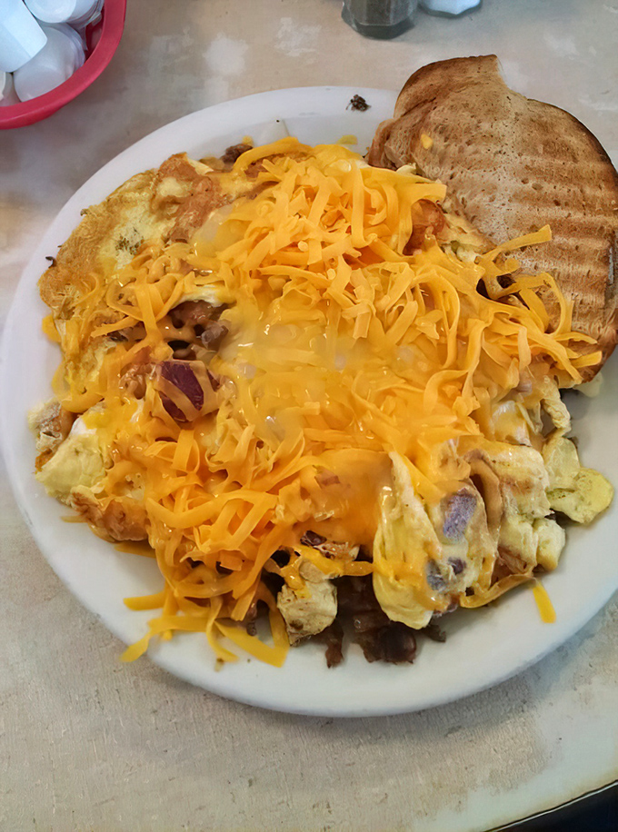 When cheese meets eggs meets corned beef, magic happens. This scrambler is what breakfast dreams are made of—hearty, unpretentious, and gloriously excessive.