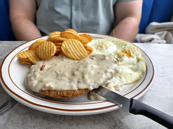 Country fried steak smothered in creamy gravy alongside sunny-side-up eggs—the kind of breakfast that makes you want to skip lunch altogether.