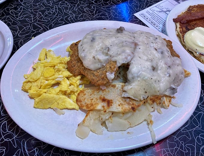 Country fried steak smothered in peppery gravy alongside golden scrambled eggs – the breakfast that fueled America's greatest generation.