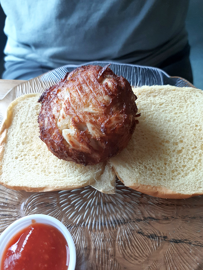 A proper crab cake sandwich needs nothing more than bread to frame it—like putting the Mona Lisa in a simple frame to let the masterpiece speak.