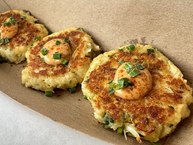 These crab cakes aren't playing the filler game. Mostly crab, barely bound, and topped with a single shrimp—like a cherry on top of seafood paradise.