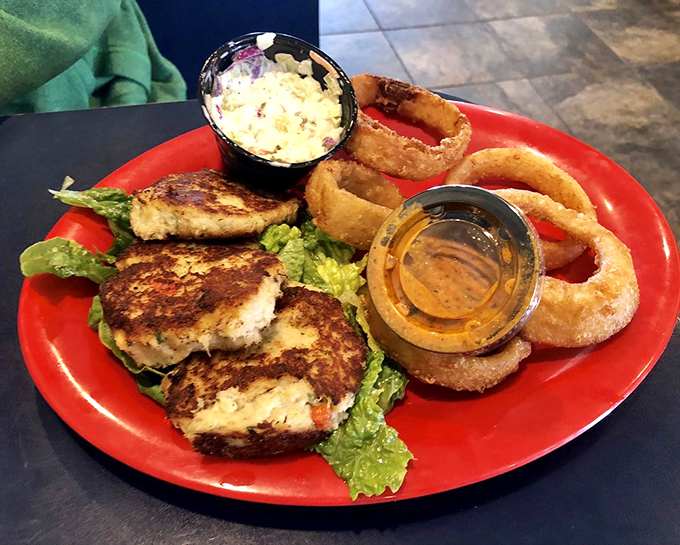 Crab cakes that actually taste like crab—what a concept! Served with those onion rings that make you temporarily forget about your diet promises.