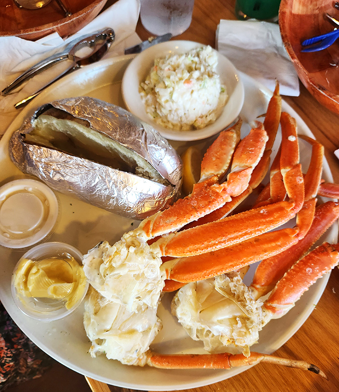 Snow crab legs splayed like a sunburst around a baked potato – nature's perfect design for both crustacean and dinner presentation.