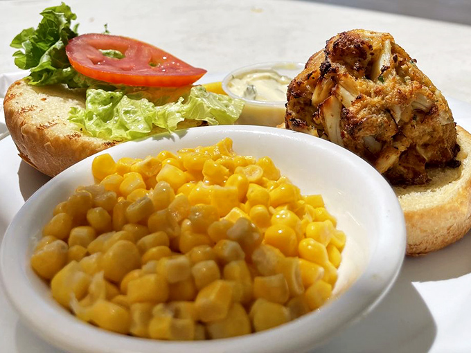 The crab cake sandwich arrives like royalty, accompanied by sweet corn and a bun that knows its supporting role perfectly.