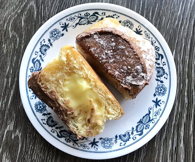 Cut one open and witness the miracle: custard-filled donuts revealing their creamy secrets. Like edible treasure chests where X marks the spot for your taste buds. 