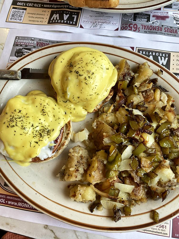 Eggs Benedict with hollandaise that would make Julia Child nod in approval, alongside home fries that refuse to be mere sidekicks.