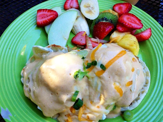 Eggs Benedict reimagined with coastal flair. The fresh fruit side isn't an afterthought—it's the perfect counterpoint to creamy hollandaise heaven.