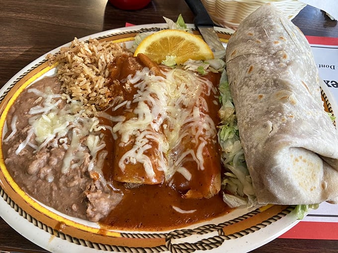 The holy trinity of Mexican comfort food: enchiladas bathed in red sauce, a burrito standing proud, and the rice and beans no plate should be without.