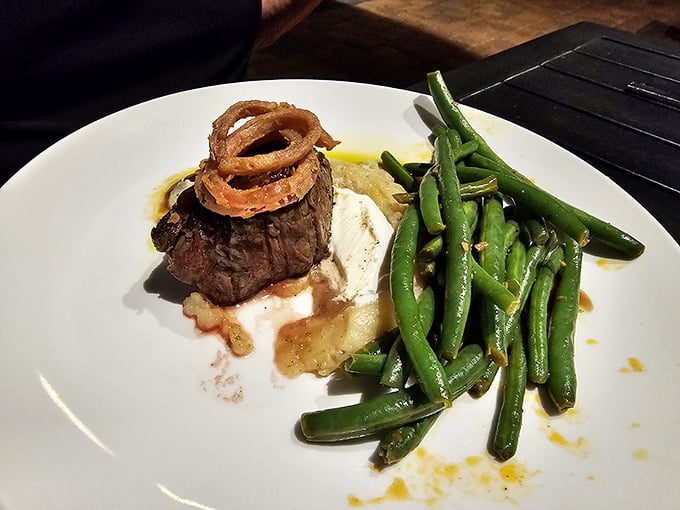 This isn't just a steak—it's a masterpiece with a supporting cast of crispy onion rings and green beans that actually deserve applause.