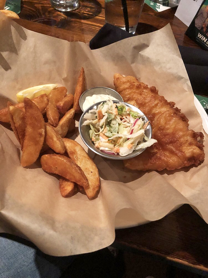 Fish and chips done right – golden-battered fish with a perfect crunch, chunky chips, and that essential side of slaw.