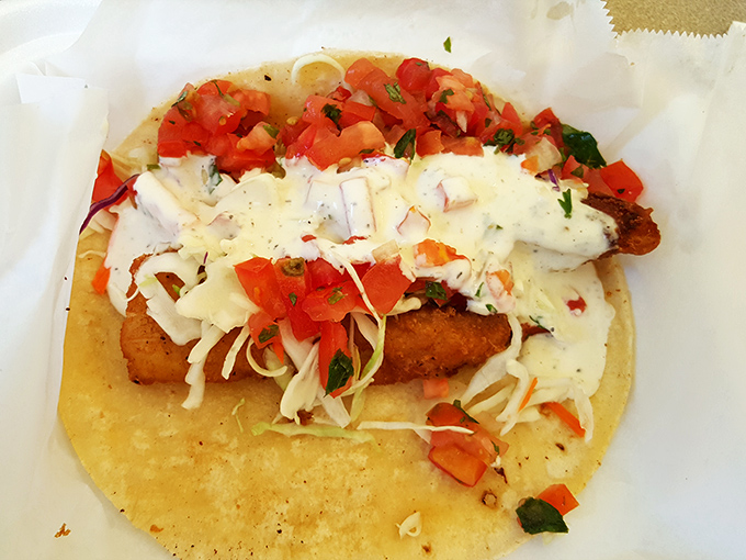 These rolled tacos aren't just topped with cheese—they're wearing a magnificent golden crown worthy of Mexican royalty.