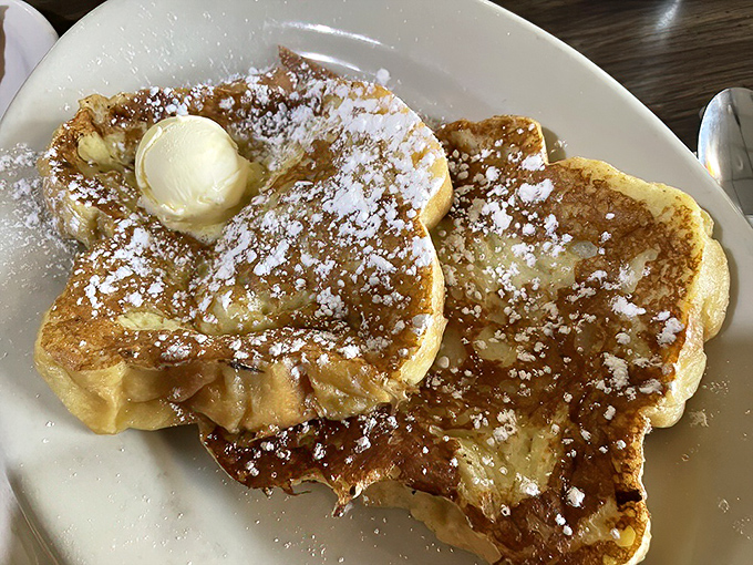 French toast that's achieved celebrity status – golden, butter-kissed, and dusted with powdered sugar like fresh snow on a perfect winter morning.