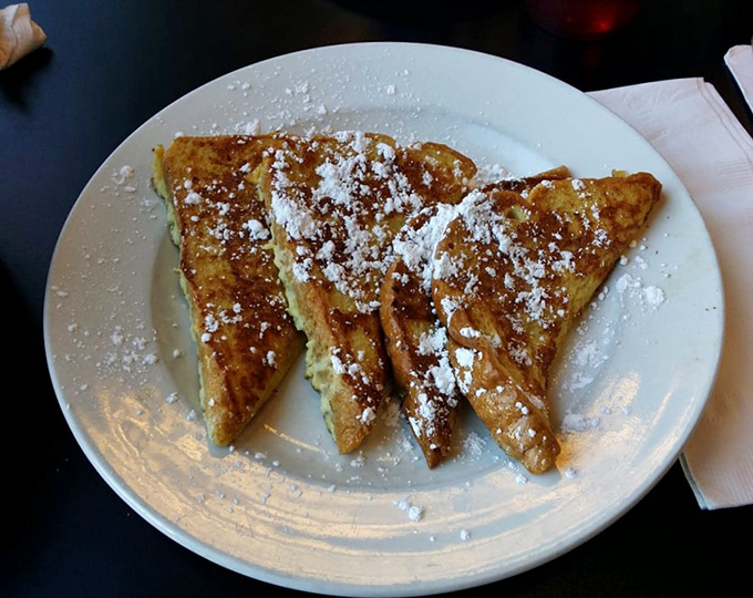 French toast that's crossed the line from breakfast to dessert, dusted with powdered sugar like fresh snow on a perfect winter morning.