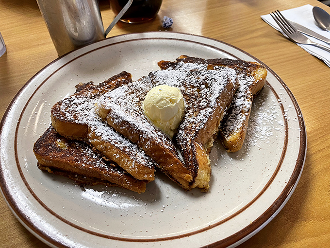 French toast dusted with powdered sugar and topped with a melting pat of butter—breakfast masquerading as dessert, and nobody's complaining.