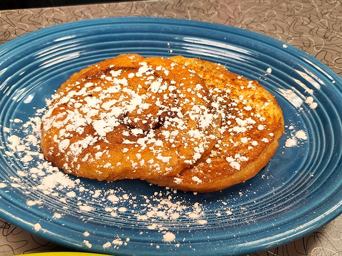 Not all heroes wear capes – some, like this powdered sugar-dusted cinnamon roll, wear a sweet glaze and wait patiently on blue plates.