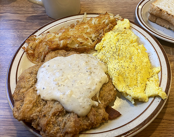 Country fried steak with eggs and hash browns—the breakfast trinity that's converted more morning skeptics than Sunday sermons. This plate doesn't just feed you—it sustains you.