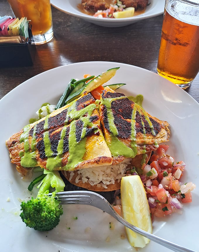 Grilled fish sporting grill marks like designer stripes, drizzled with vibrant green sauce. That broccoli floret is the world's smallest cheerleader for healthy eating.
