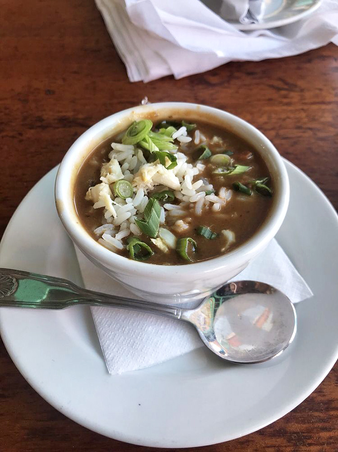 A proper seafood gumbo that's darker than a Florida thundercloud, topped with rice and green onions—liquid comfort in a bowl.