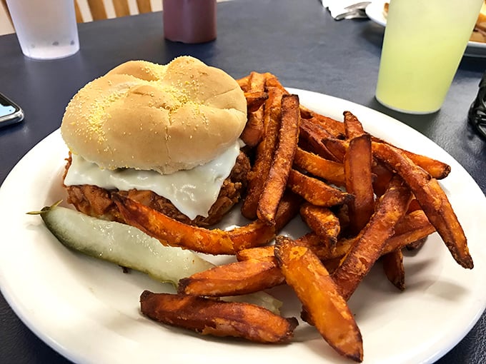 A sandwich that means business, flanked by sweet potato fries that could start their own fan club. This plate doesn't just satisfy—it conquers.