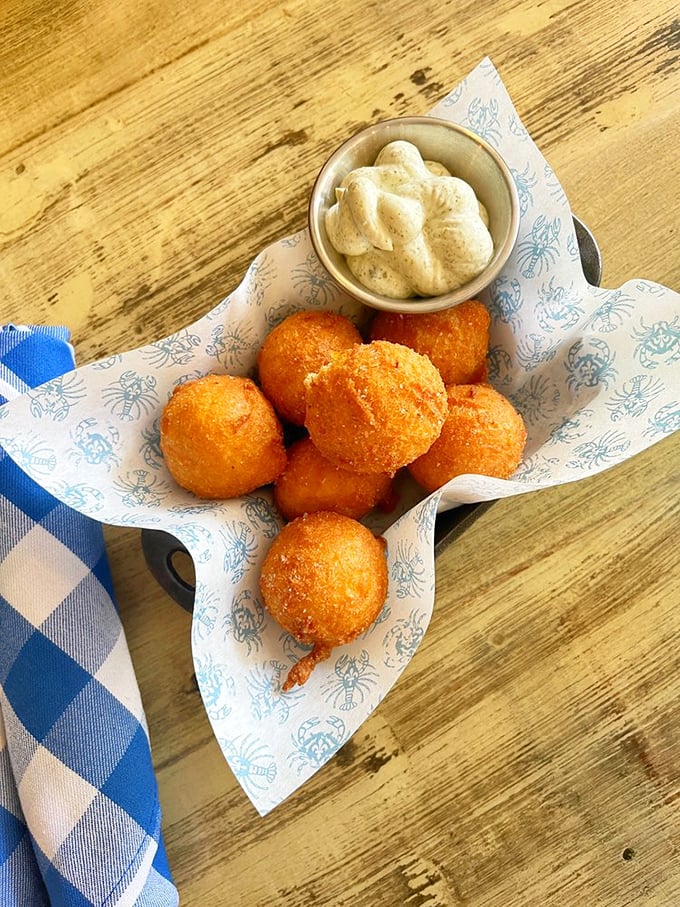 These golden hush puppies aren't just fried cornmeal – they're little spheres of Southern comfort that somehow taste like childhood memories.
