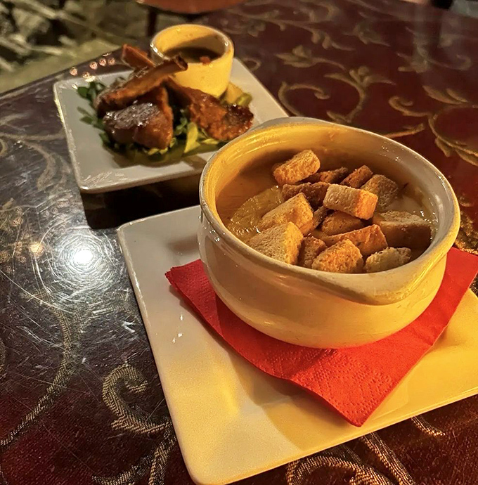 A tale of land and sea on one plate: tender meat lollipops alongside a golden soup that carries whispers of the ocean in every spoonful.