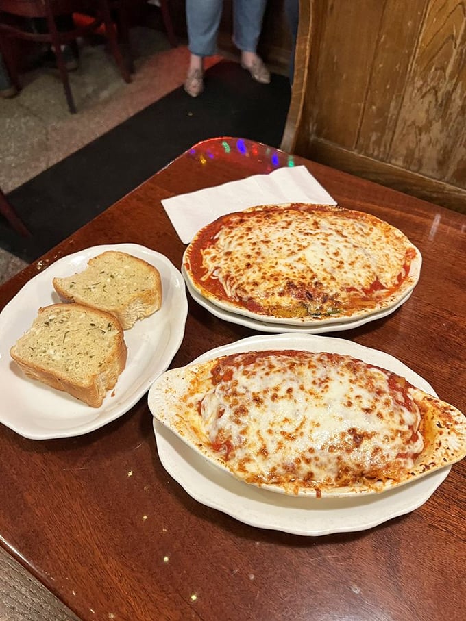 These pasta dishes arrive looking like they just auditioned for a food commercial – bubbling cheese, rich sauce, and garlic bread ready for its supporting role.