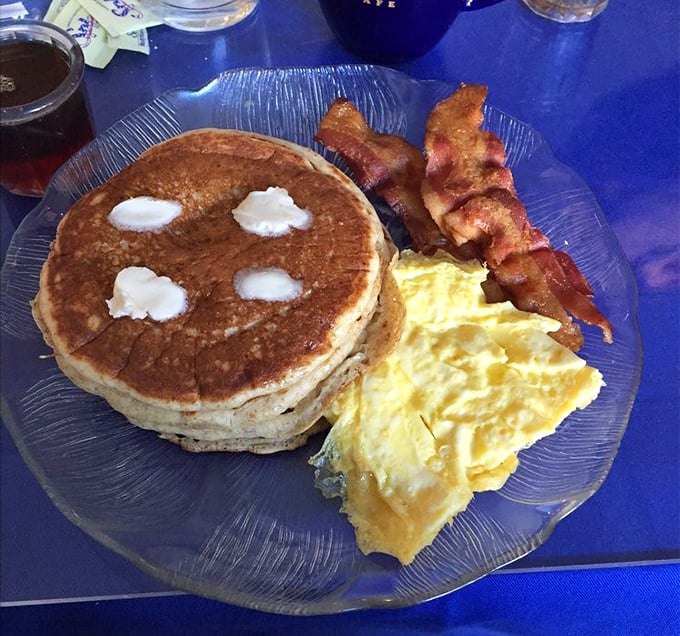 The breakfast trinity—golden pancake, scrambled eggs, and bacon that's achieved that perfect crisp-yet-chewy texture that breakfast dreams are made of.
