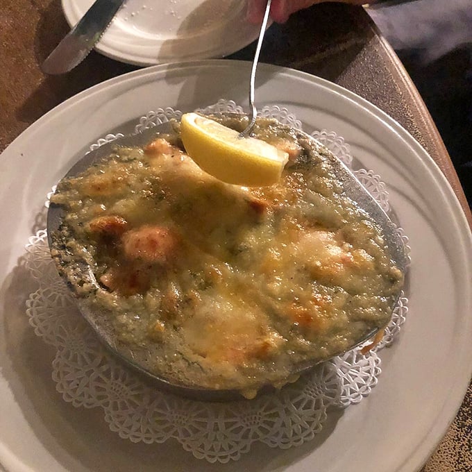 Lobster "escargot style" proves that butter, garlic, and cheese make everything better, especially when there's a lemon wedge standing by for that perfect citrus kick.