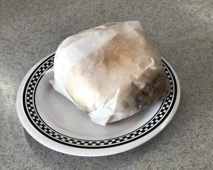 Not all heroes wear capes—some come wrapped in wax paper. This hefty sandwich promises to vanquish hunger with every substantial bite.
