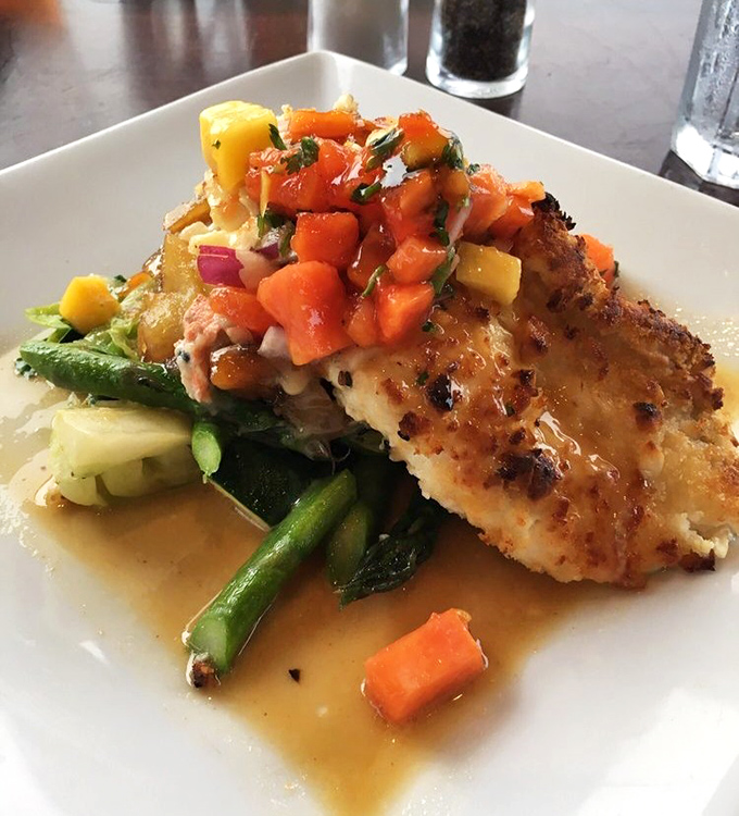 Macadamia-crusted fish perched atop vibrant vegetables—proof that sometimes the prettiest dishes are also the most delicious.