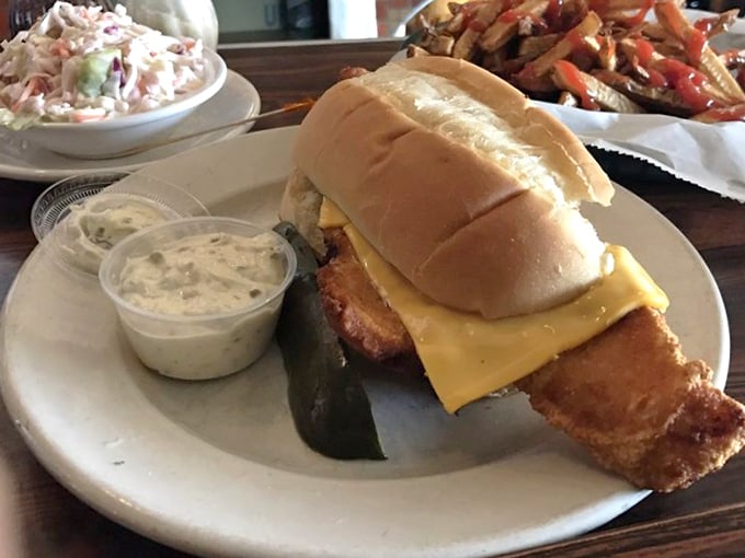 The fish sandwich that launched a thousand napkins – hand-breaded cod extending well beyond its bun's jurisdiction, with tartar sauce standing by for backup. 