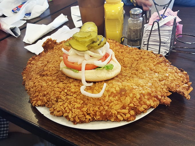 Indiana's unofficial state sandwich in its natural habitat – a tenderloin so massive it requires strategic planning just to take the first bite.