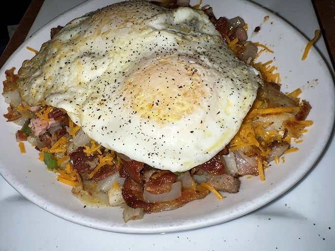 A skillet that could fuel a marathon—eggs perched atop a mountain of potato, meat, and cheese. Breakfast architecture at its finest.