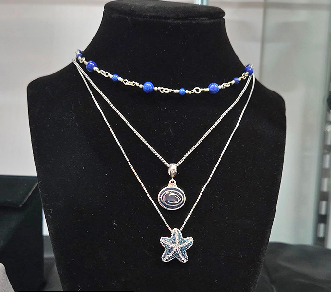Delicate necklaces featuring Penn State logos and starfish pendants—proof that second-hand jewelry still carries first-rate charm.