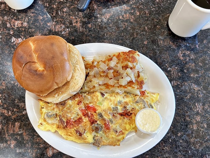 An omelet that's clearly been to college—stuffed with knowledge and potential. Those home fries look like they've been gossiping with butter and salt.