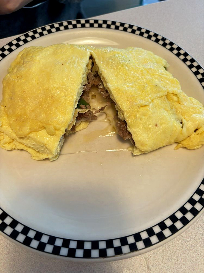 An omelet so perfectly folded it could teach origami classes, revealing a treasure of fillings inside. Breakfast architecture at its finest.