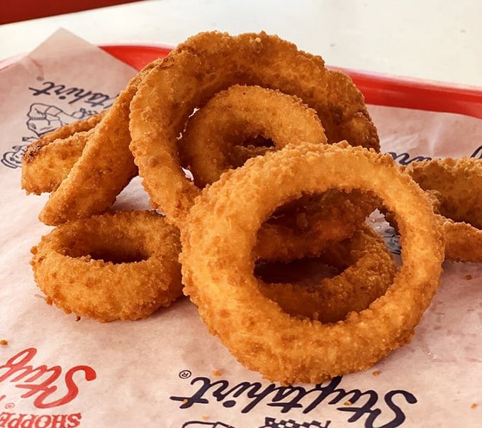 Golden rings of happiness stacked like delicious jewelry. These onion rings aren't just a side—they're the supporting actors that steal the show.