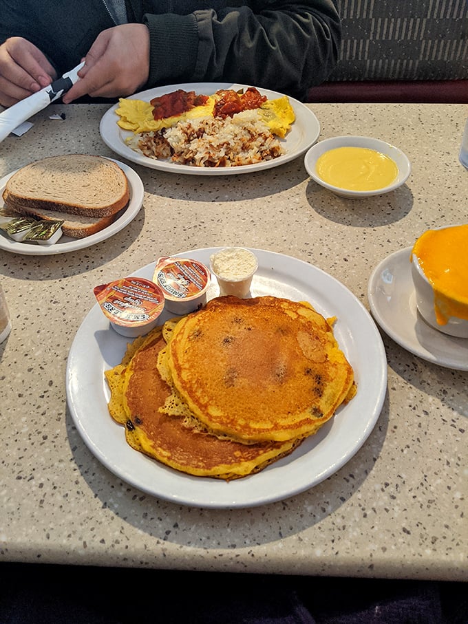 A stack of pancakes alongside eggs and hash browns—the breakfast equivalent of winning the lottery. Morning glory on a plate.