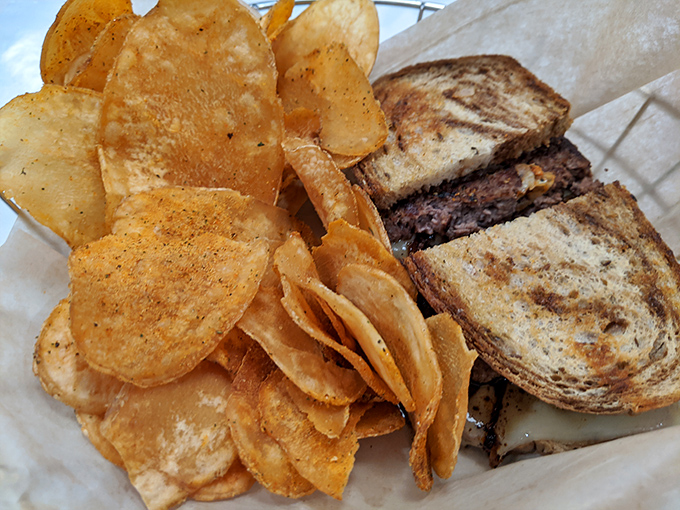 House-made chips that shatter with each bite, flanking a sandwich that understands the perfect meat-to-bread ratio is non-negotiable.