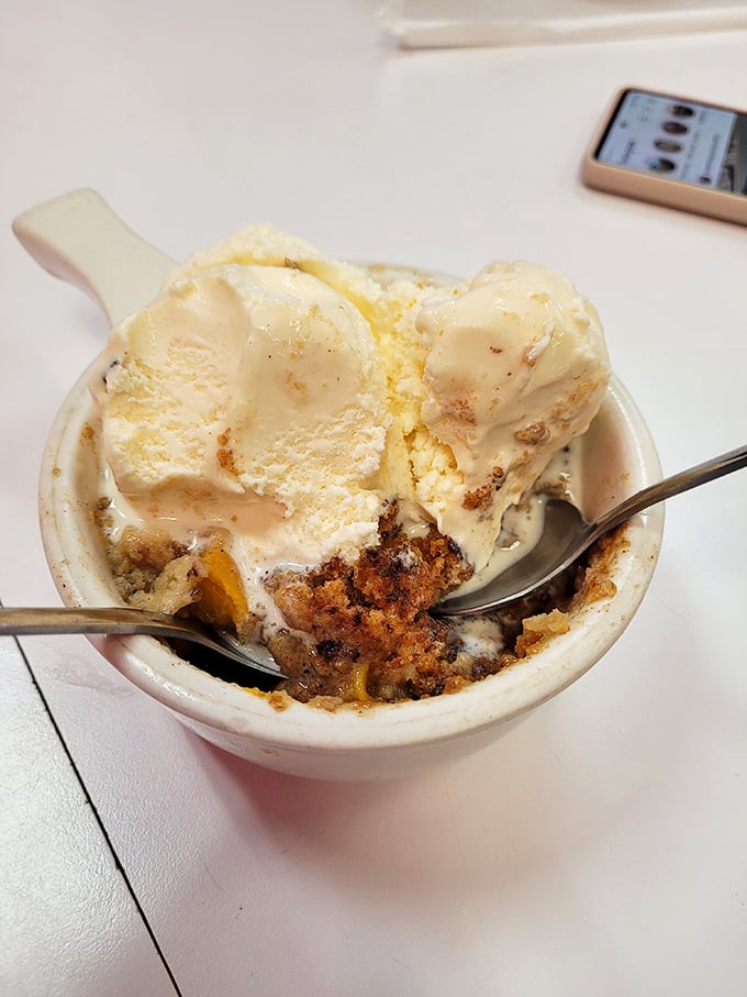 Warm peach cobbler meets cold vanilla ice cream in a bowl—proof that opposites don't just attract, they create culinary fireworks worth every calorie.