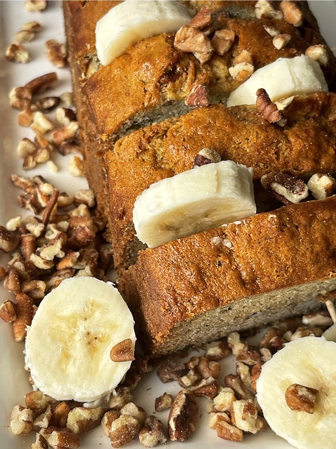 Banana bread elevated to art form with fresh banana slices and crunchy pecans. Grandma would approve—and maybe take notes.